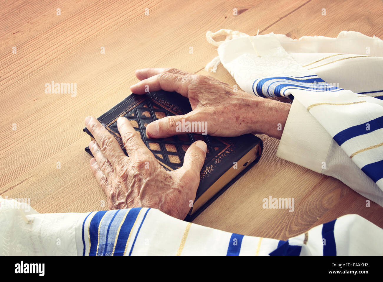 Old Jewish man hands holding a Prayer book, praying, next to tallit ...
