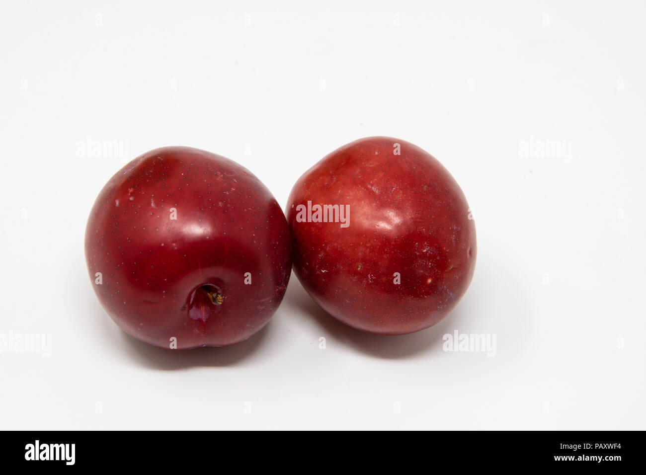 A photo of two plums on a white background Stock Photo - Alamy