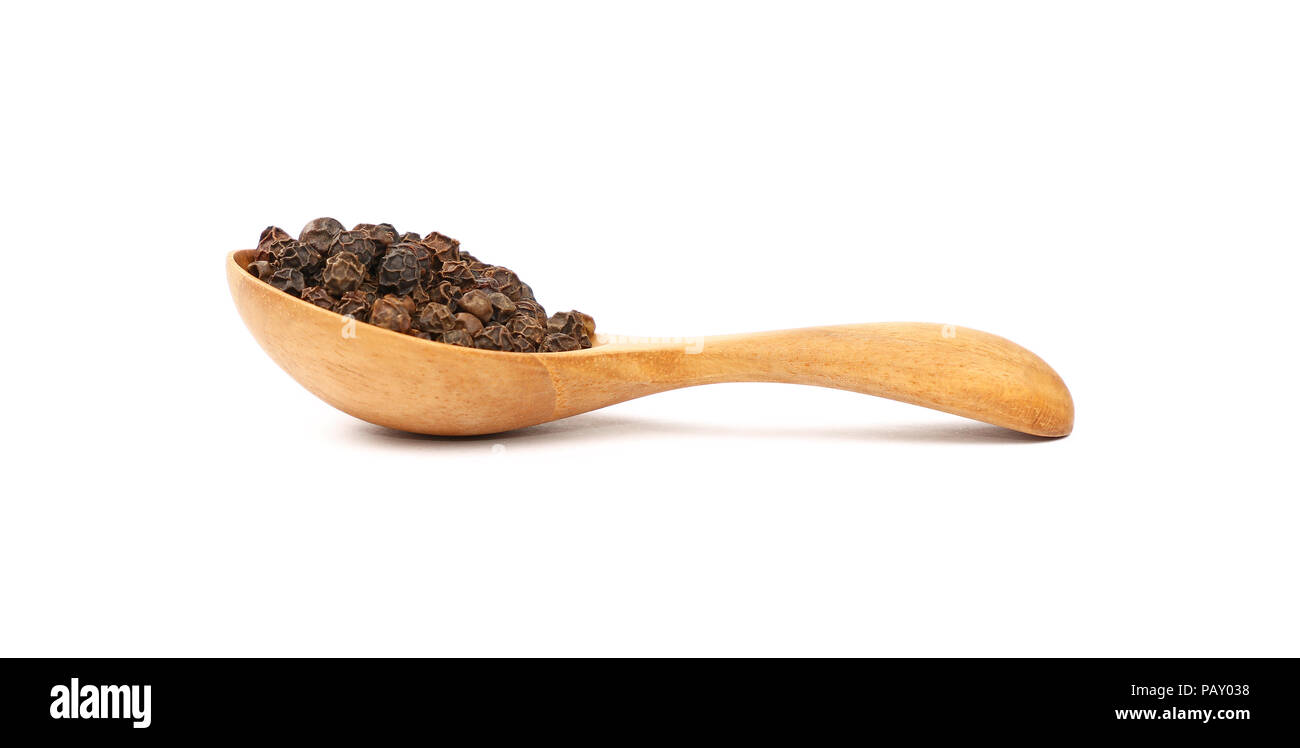 Close up one wooden scoop spoon full of black pepper peppercorns ...
