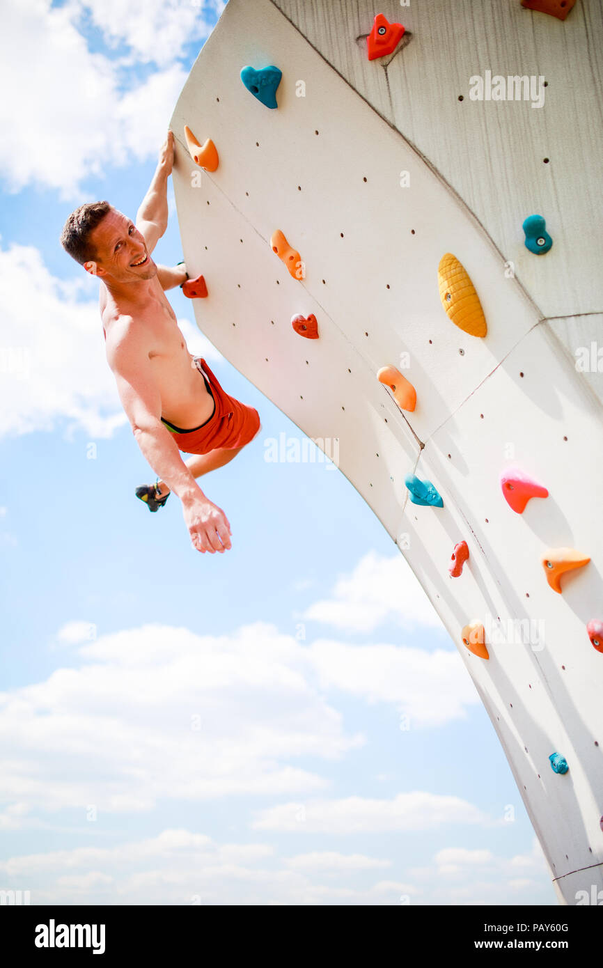 Photo of smiling athlete man looking at camera practicing on wall for ...