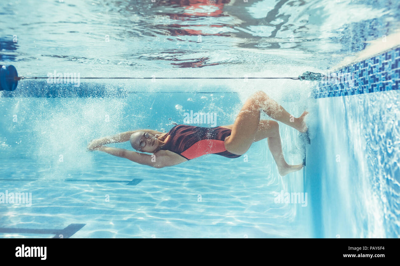 Shot of professional swimmer turning over underwater while swimming ...