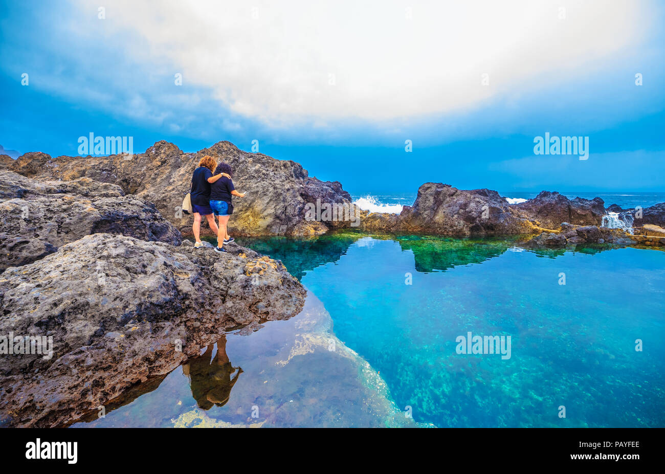 Tourists discovering traditional swimming pools of Garachico resort, in ...