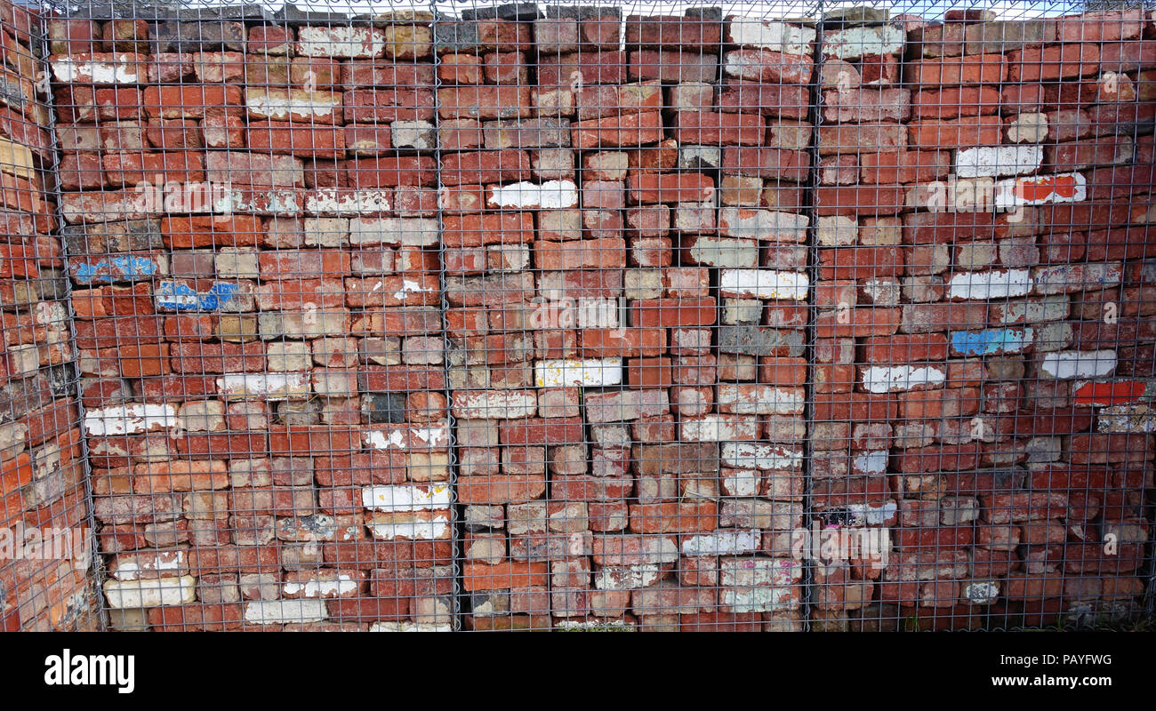 Stacks of used red bricks, covered in wire mesh Stock Photo - Alamy
