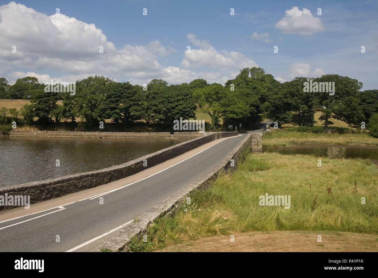 A narrow stone walled bridge carryies the A4075 road over inlet of ...