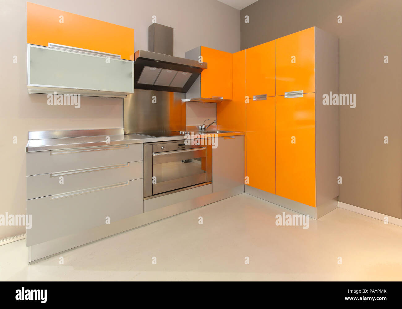 Modern orange kitchen with new appliances Stock Photo - Alamy
