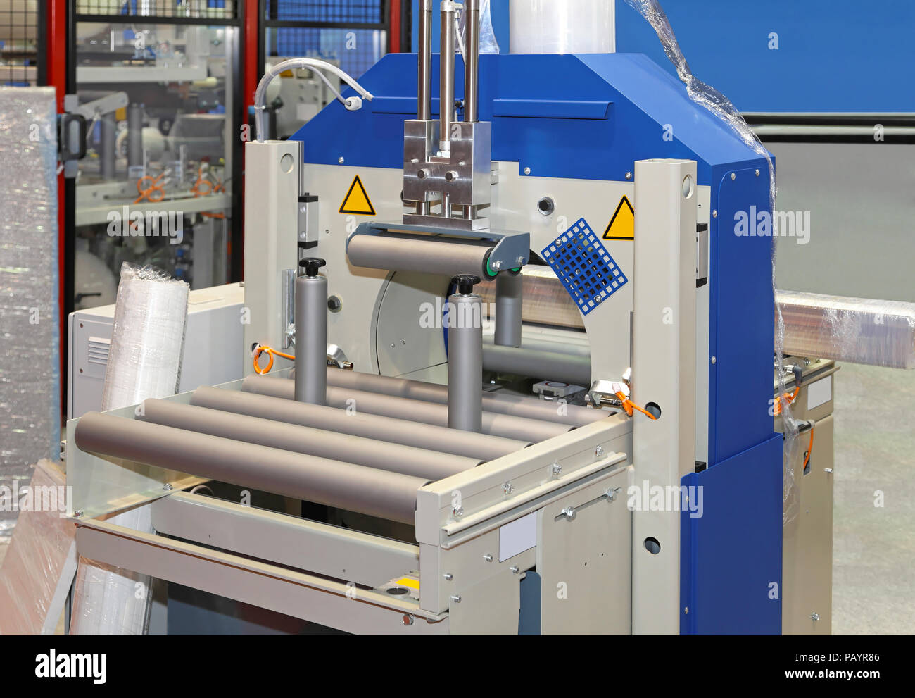 Automated machine for packing gods in foil Stock Photo - Alamy