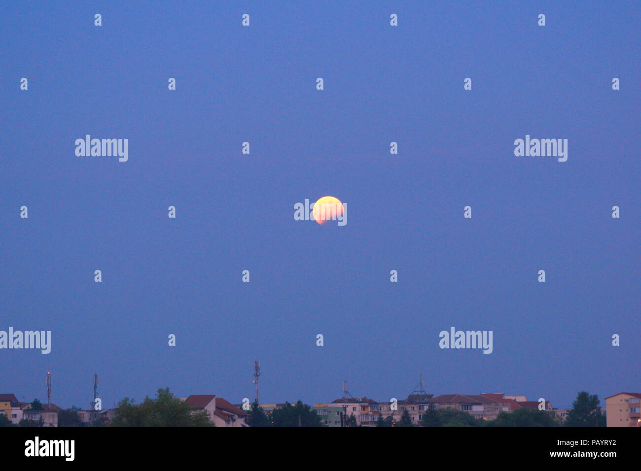 Moon eclipse over the town Stock Photo - Alamy