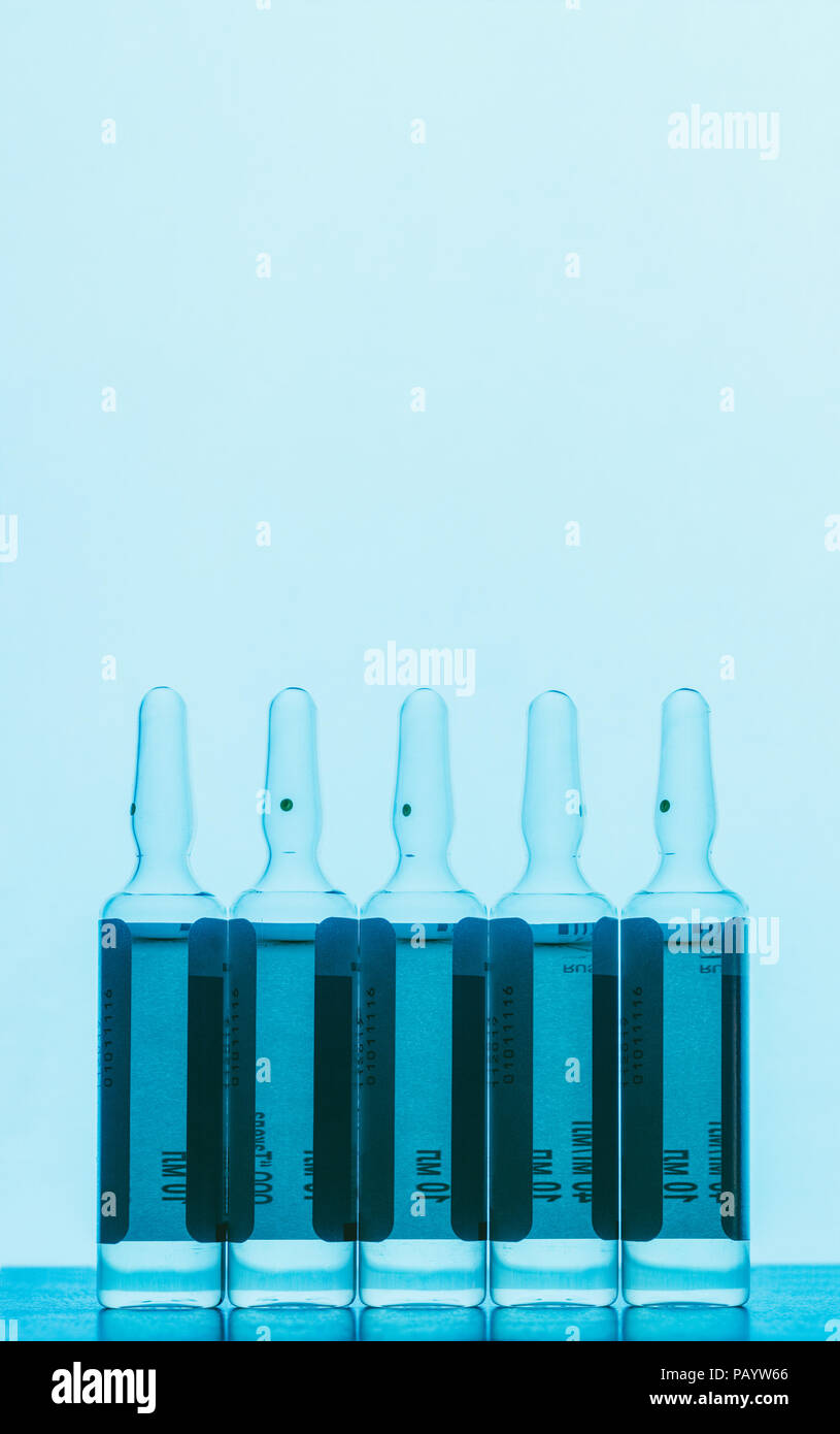 the ampoules with solution for injections on a blue background with ...