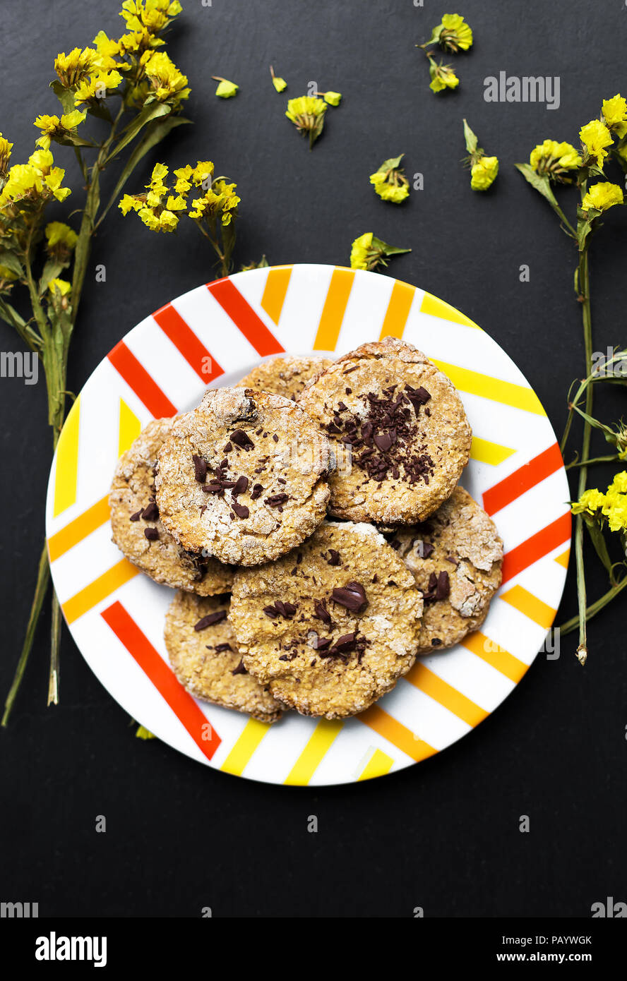 Oatmeal cookies with chocolate on a plate with bright yellow flowers ...