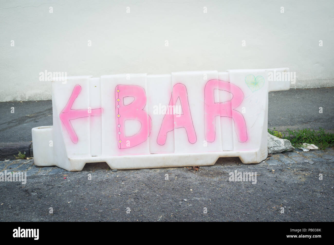 Roadside sign for a bar spray painted onto a traffic bollard, Bristol ...