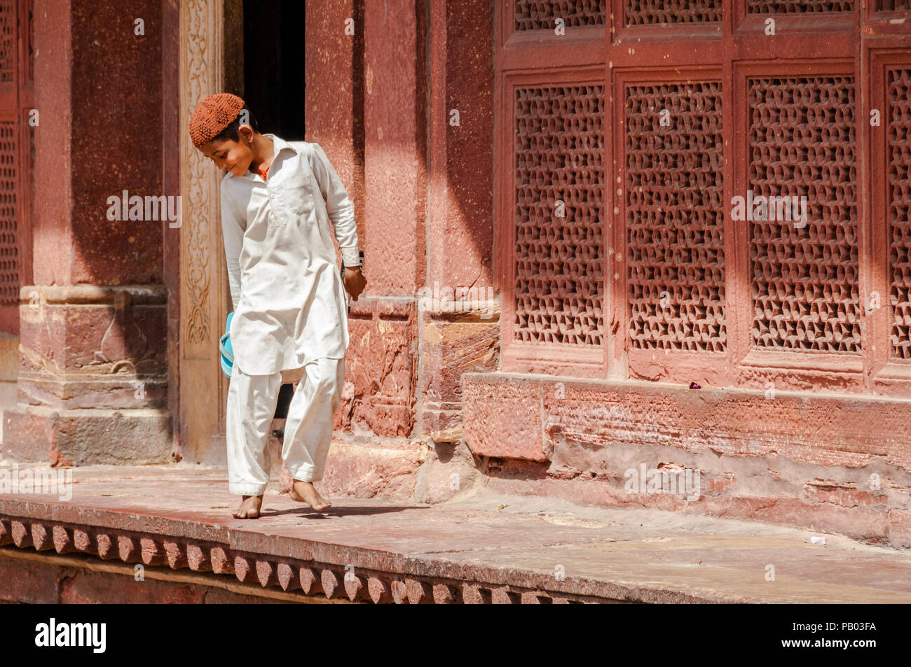 Smiling Indian boy walking through temple Stock Photo - Alamy