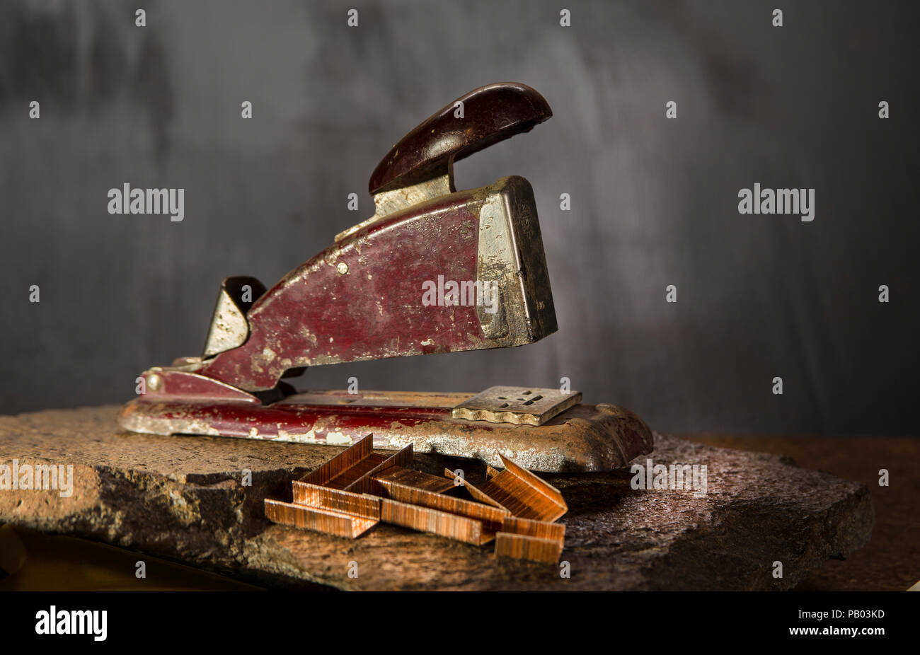 Old stapler on the stone and dark background Stock Photo - Alamy