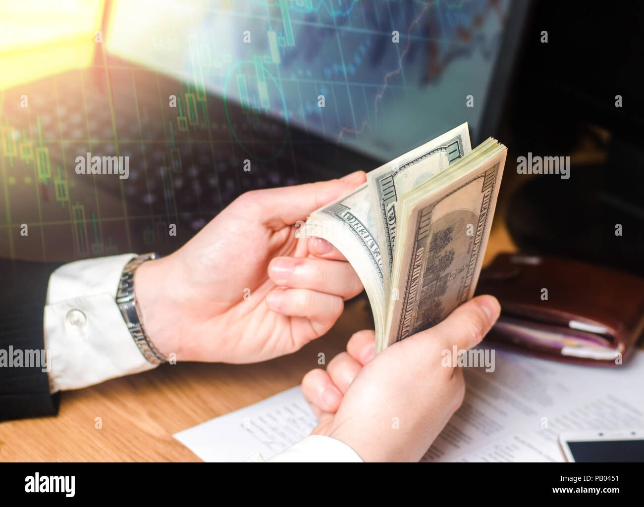 A businessman in a suit counts dollars at a table in the hands of a ...