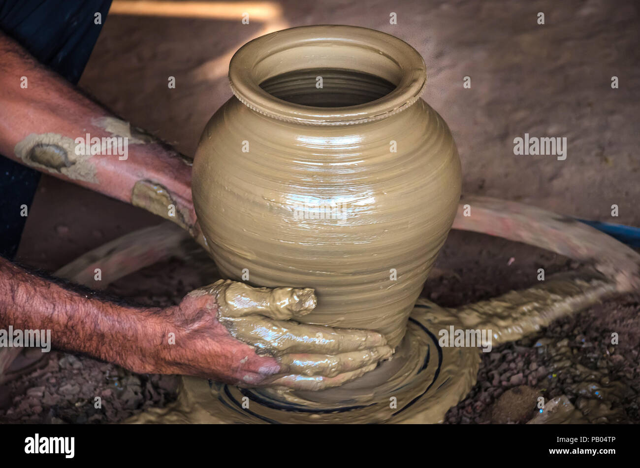 Closeup of potter's hands making clay water pot on pottery wheel. Clay ...
