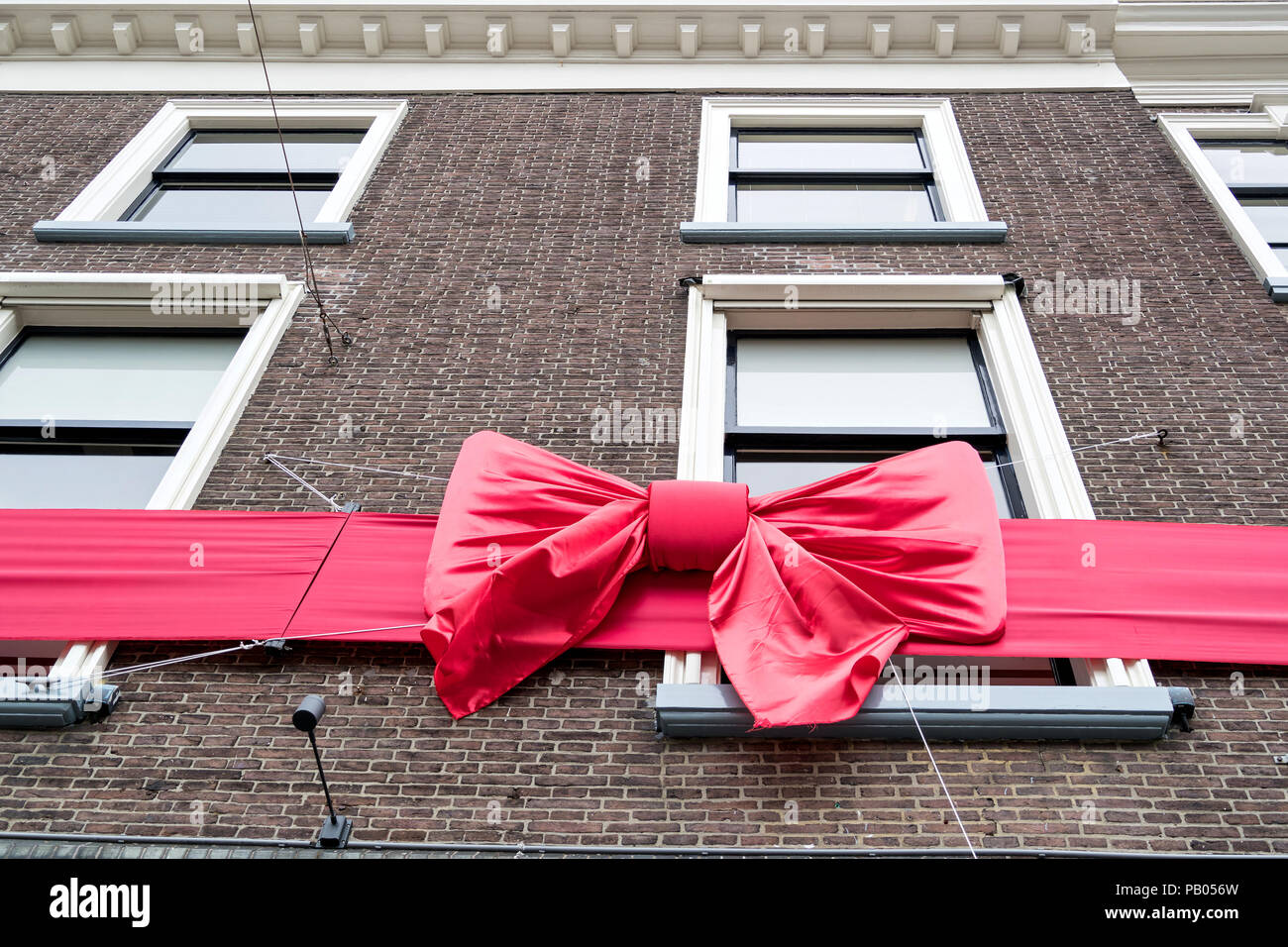 giant red ribbon at urban building Stock Photo - Alamy