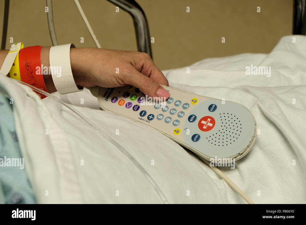 Woman patient changing television channels with remote control device ...