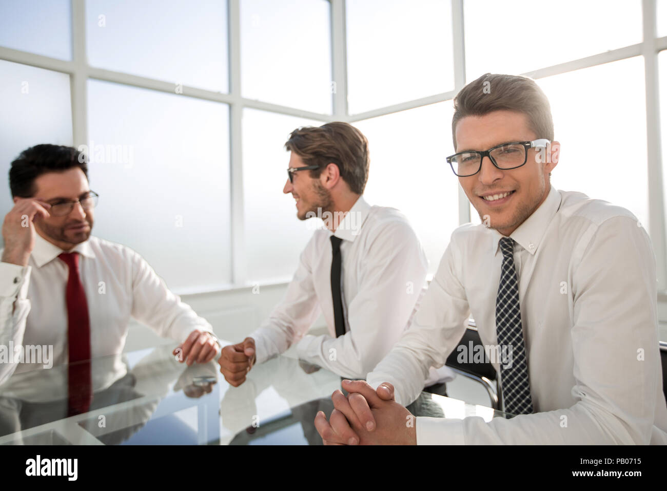 three professional employees sitting at the office table Stock Photo ...