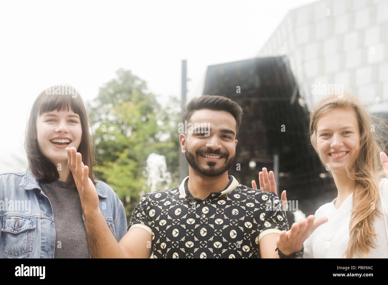 Three friends in the city standing side by side Stock Photo - Alamy