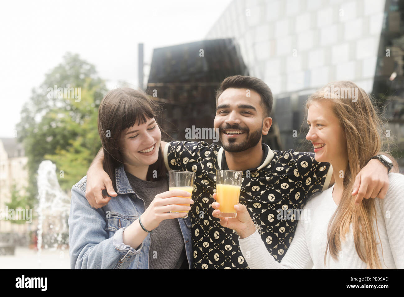 Three smiling friends making a celebratory toast Stock Photo - Alamy
