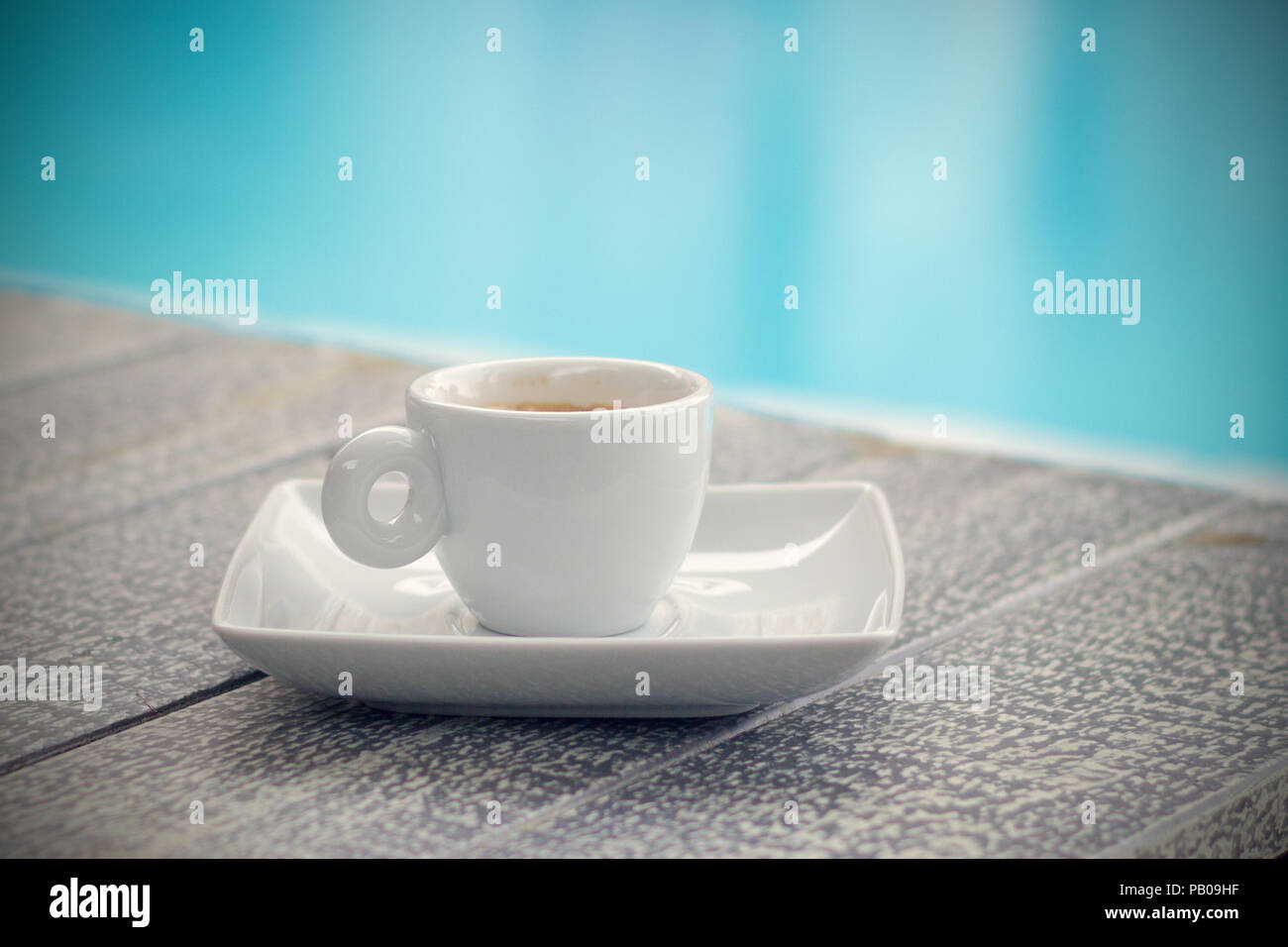 Cup of coffee next to a swimming pool Stock Photo - Alamy