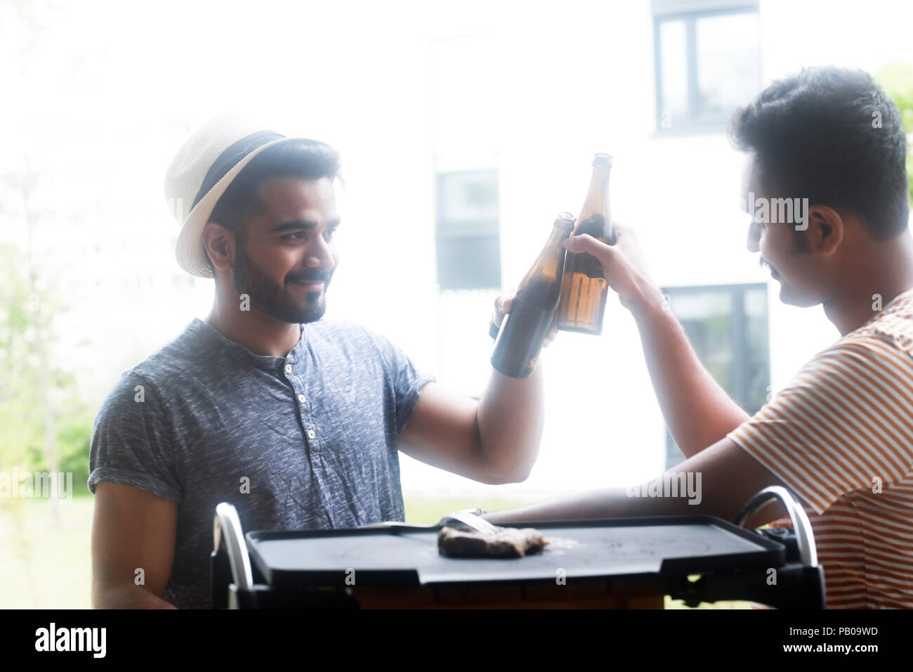 Two men making a celebratory toast at a barbecue Stock Photo - Alamy