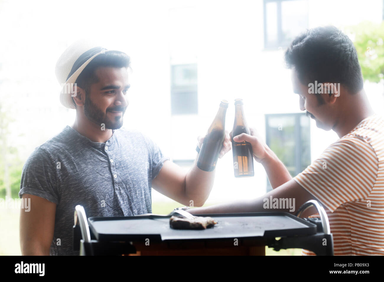 Two men making a celebratory toast at a barbecue Stock Photo - Alamy
