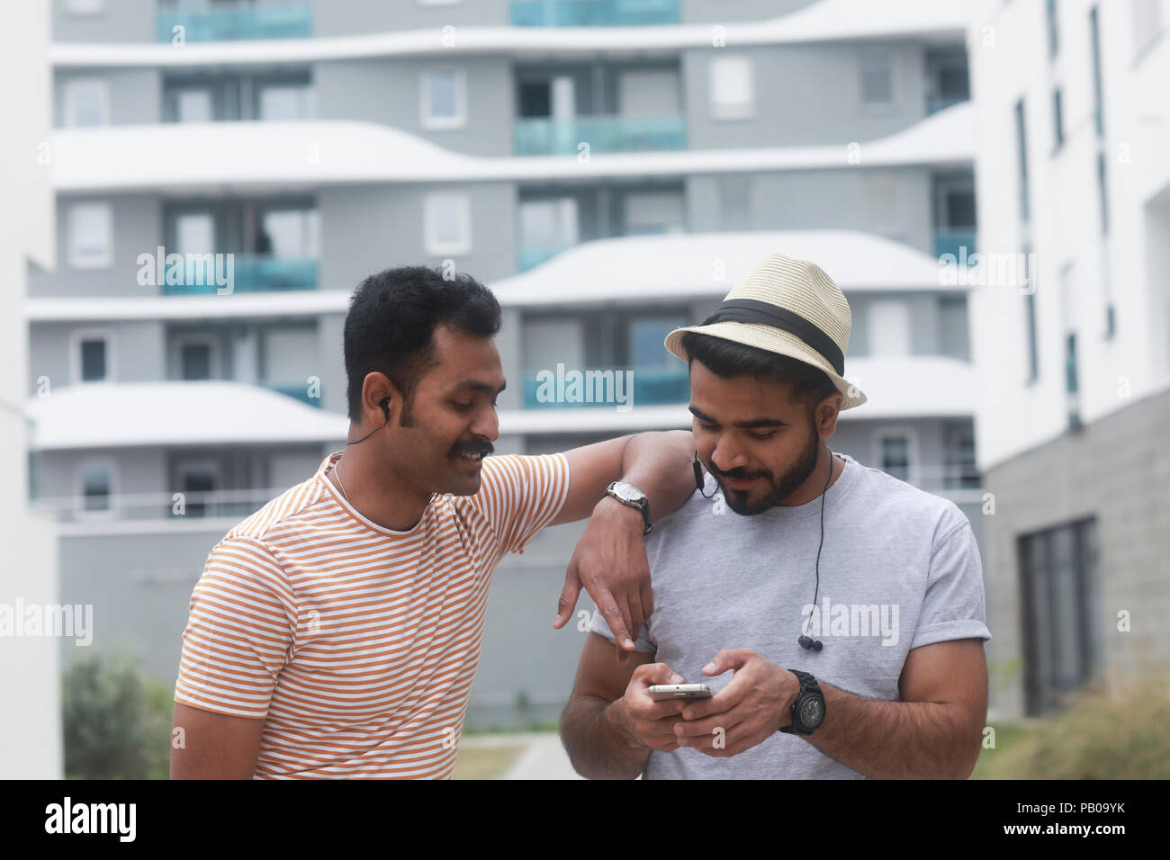 Two men listening to music on their mobile phone Stock Photo - Alamy
