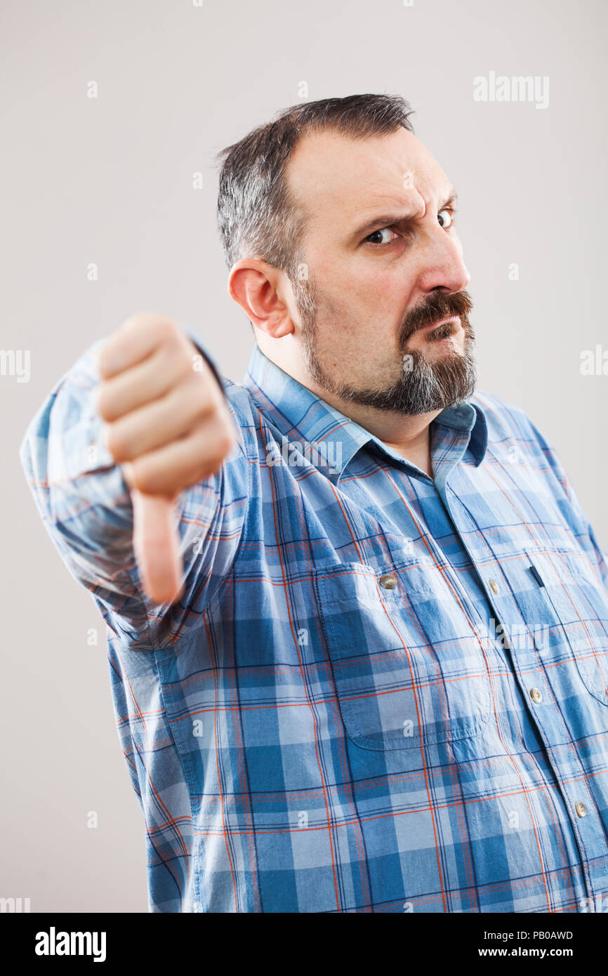 Portrait of man showing thumb down Stock Photo - Alamy