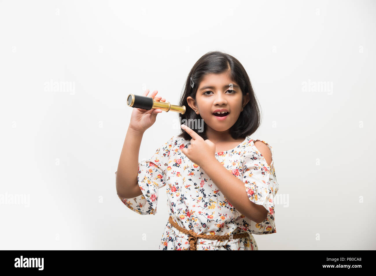 Cute little Indian/asian girl using stretch telescope and looking up in ...