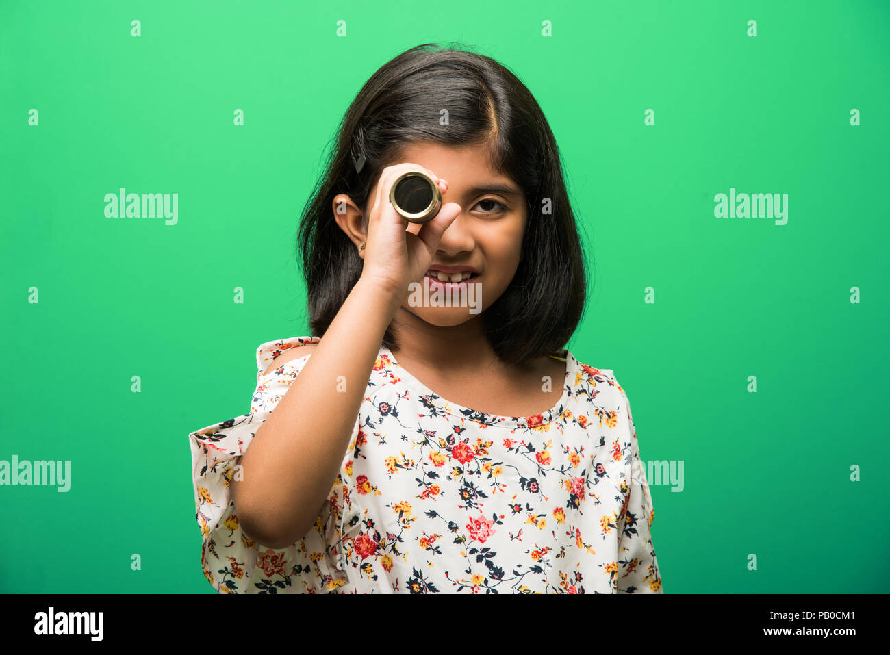 Cute little Indian/asian girl using stretch telescope and looking up in ...