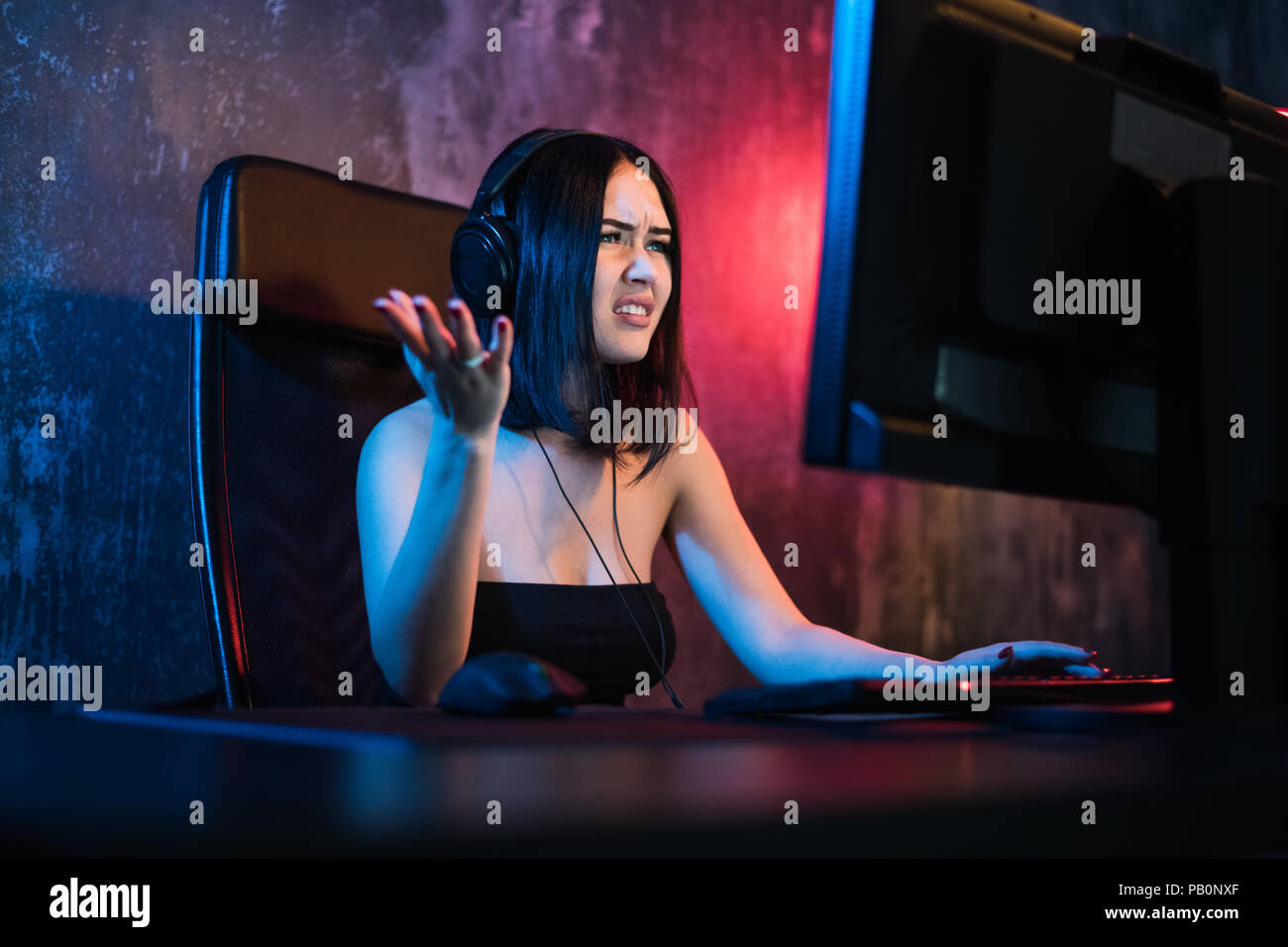Gamer girl. Excited angry shocked young woman playing video games on a ...