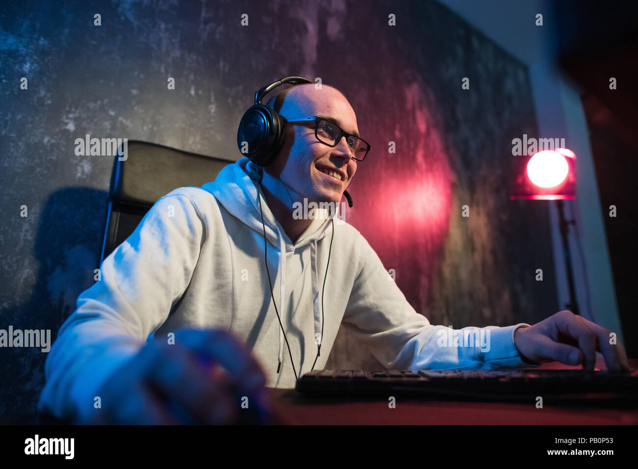 male hooded gamer playing online game on pc computer Stock Photo - Alamy