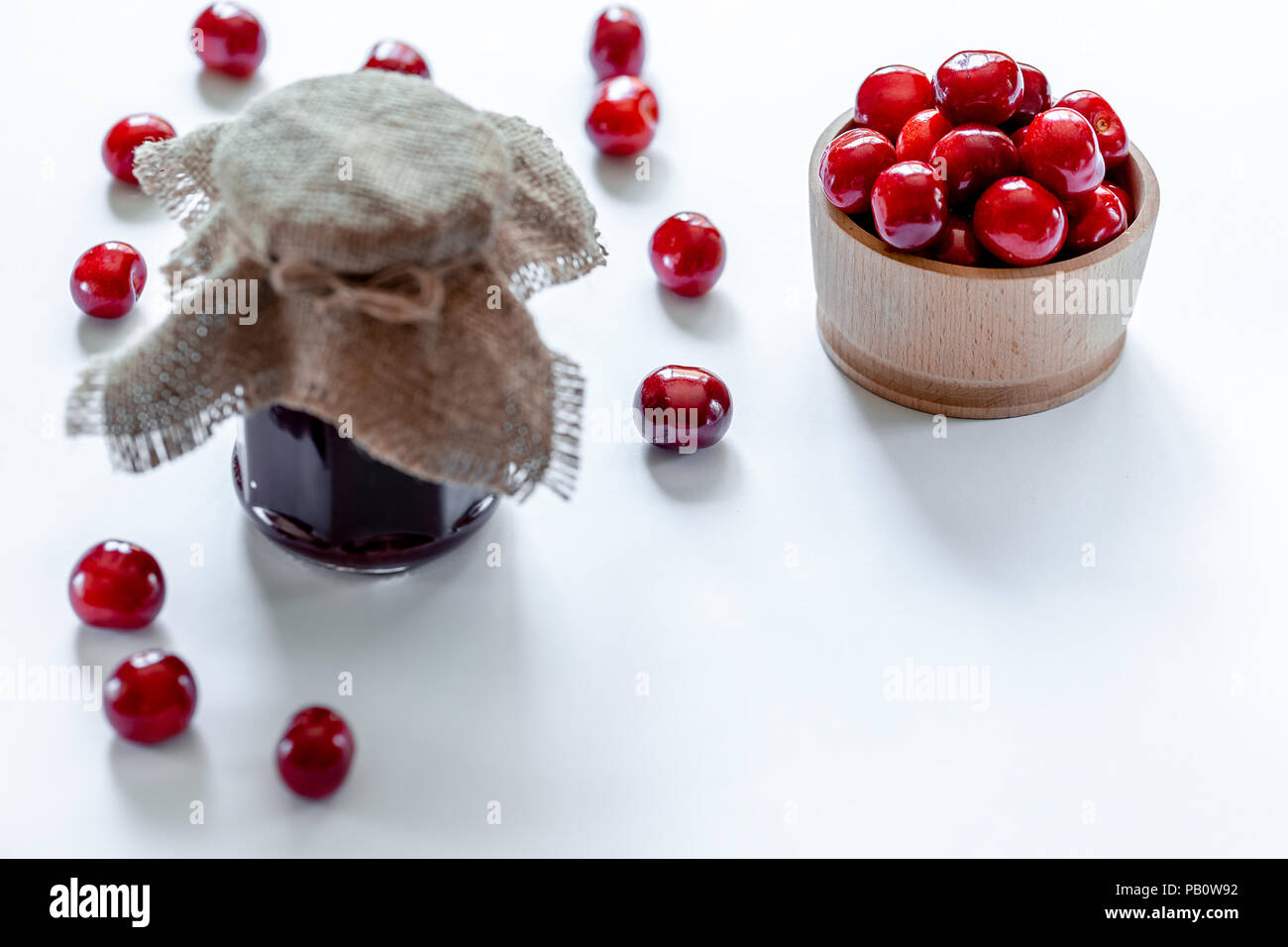 Red ripe cherries with jam jar on white background. Flat lay. Food ...