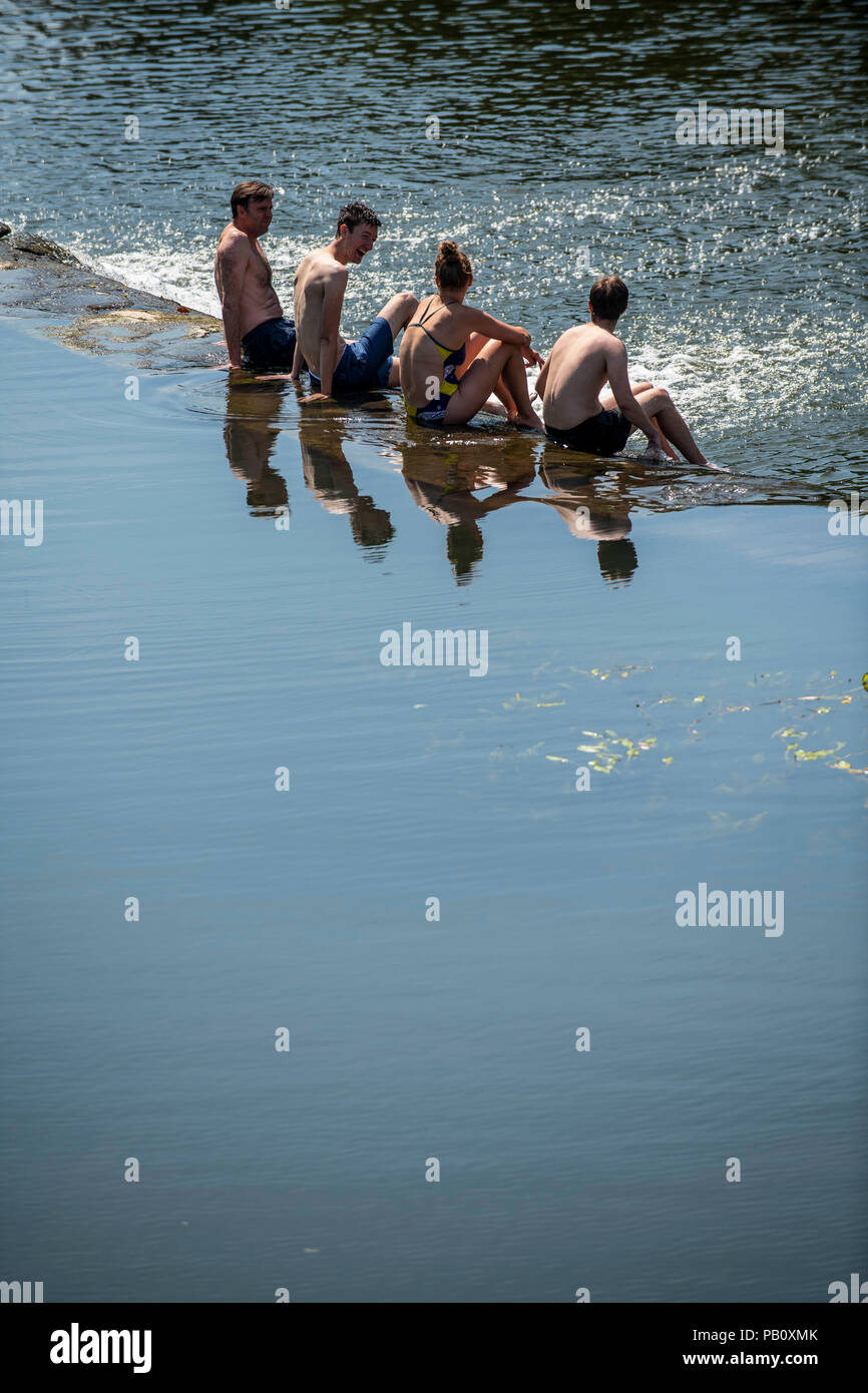 A group of people cool off on the weir at Bathampton Mill on the river ...