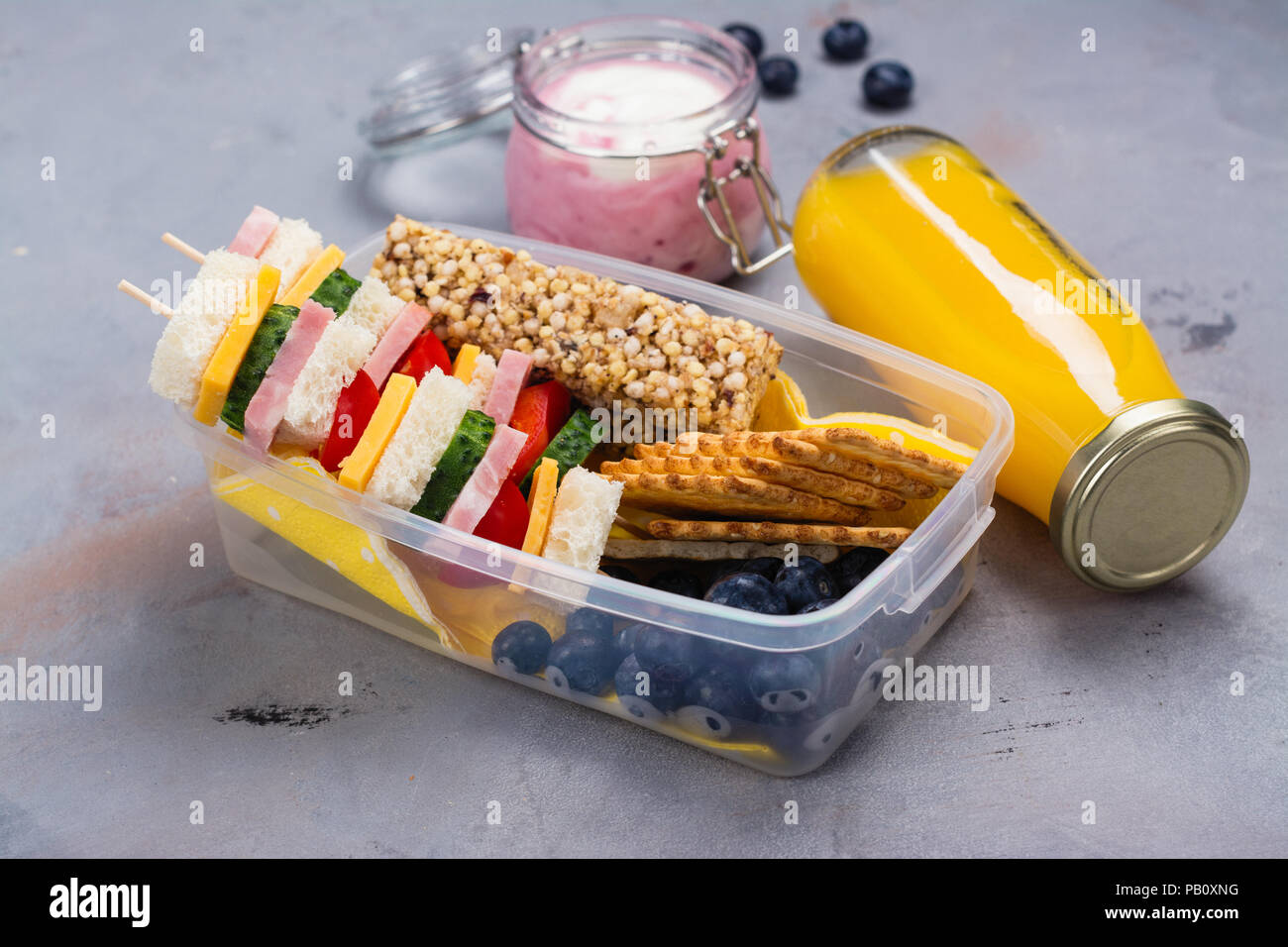 Healthy school lunch box with sandwich kabobs, yogurt, juice, fruits ...