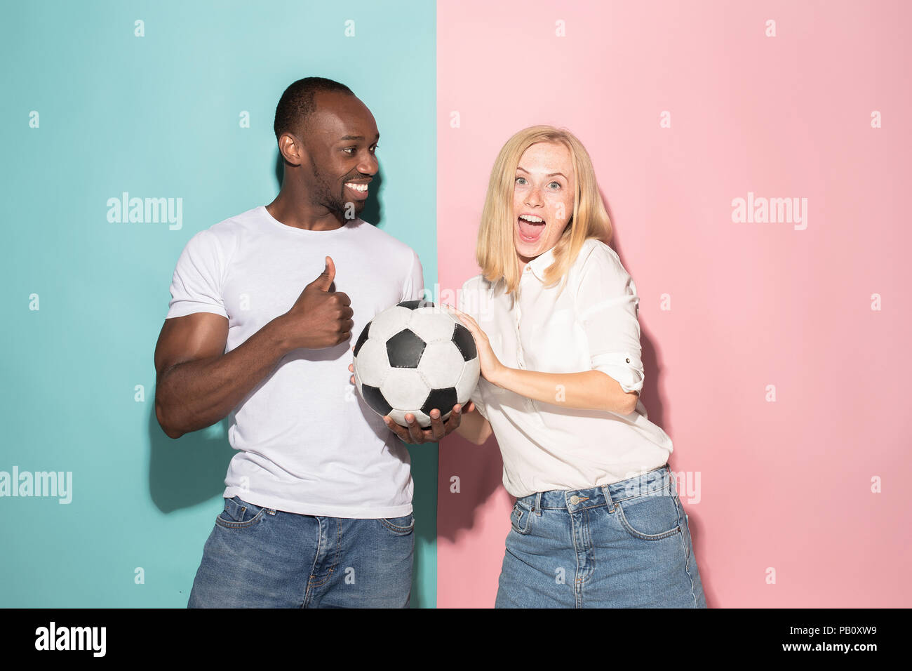 The young fans celebrating on blue and pink trendy colors Stock Photo ...