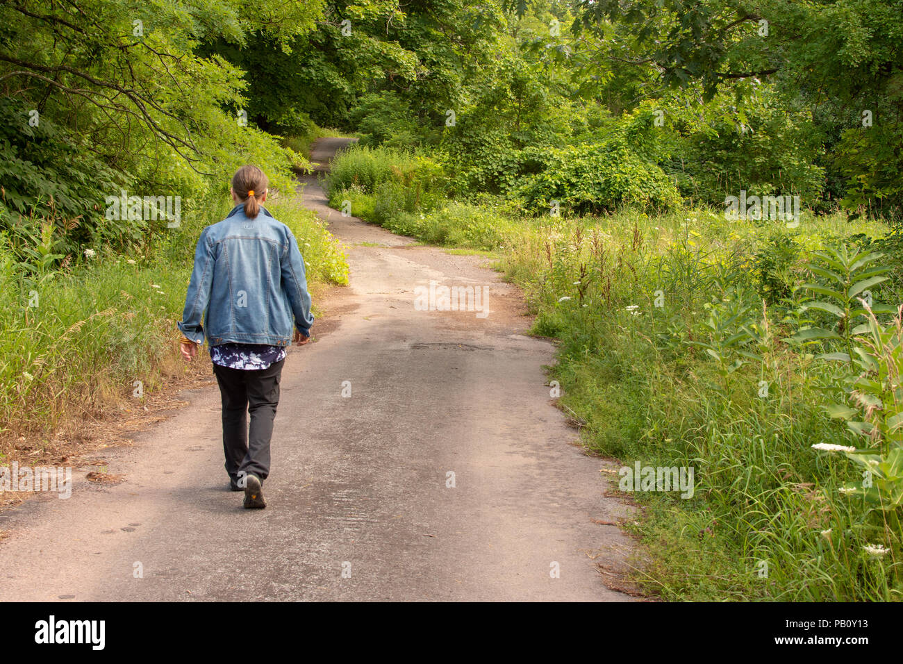 Woman walking on country lane hi-res stock photography and images - Alamy