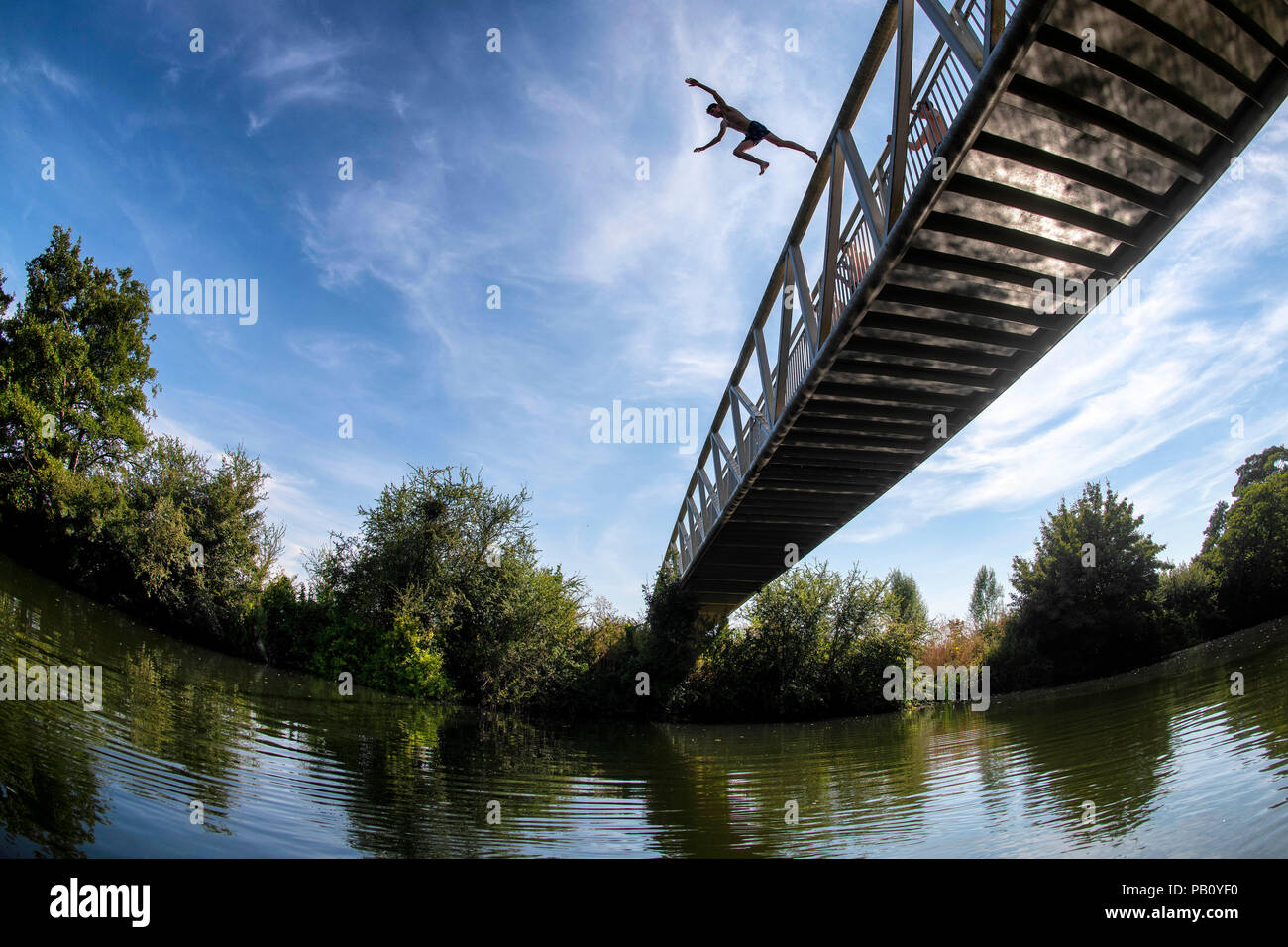 A group of teenage boys jump from a footbridge into the river Avon at ...