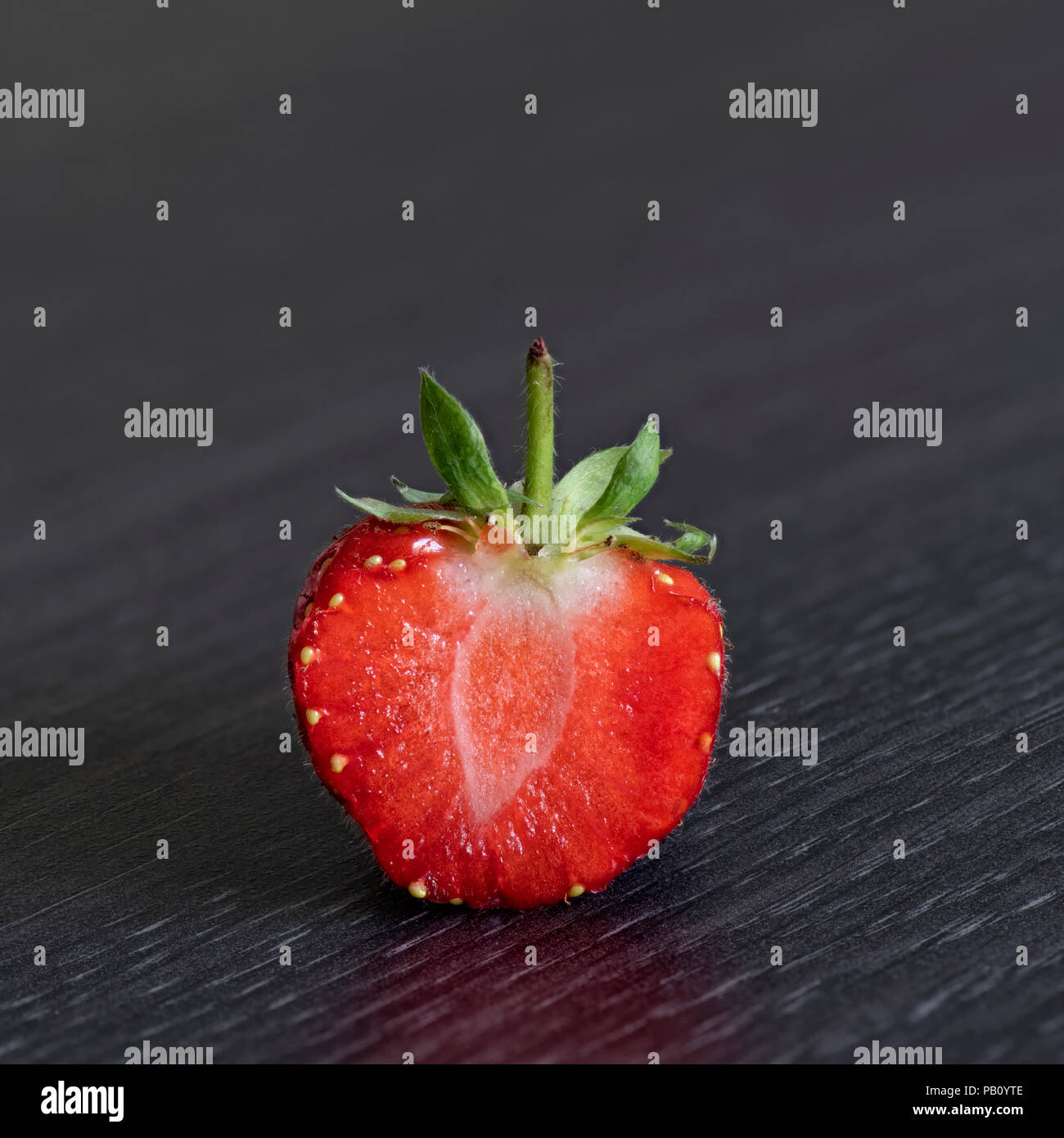single ripe strawberry cut in half showing juicy red interior Stock ...