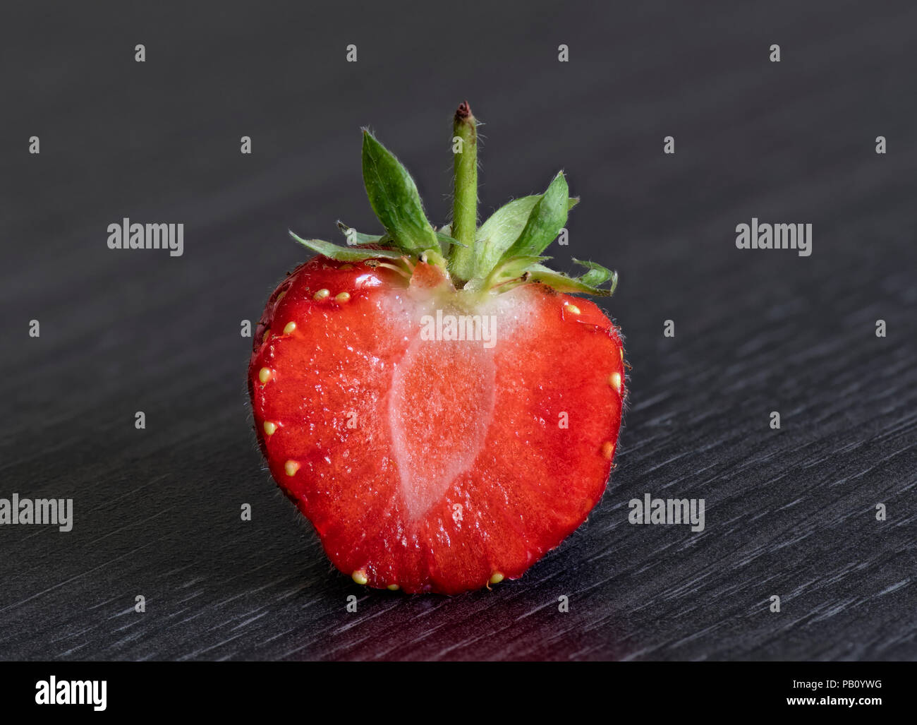single ripe strawberry cut in half showing juicy red interior Stock ...