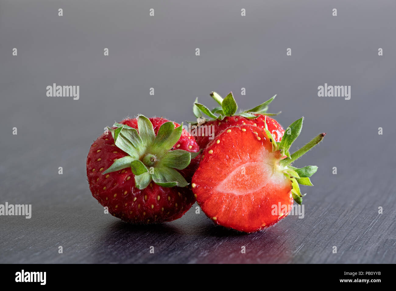 Luscious ripe fresh strawberries on a grey kitchen worktop. One ...