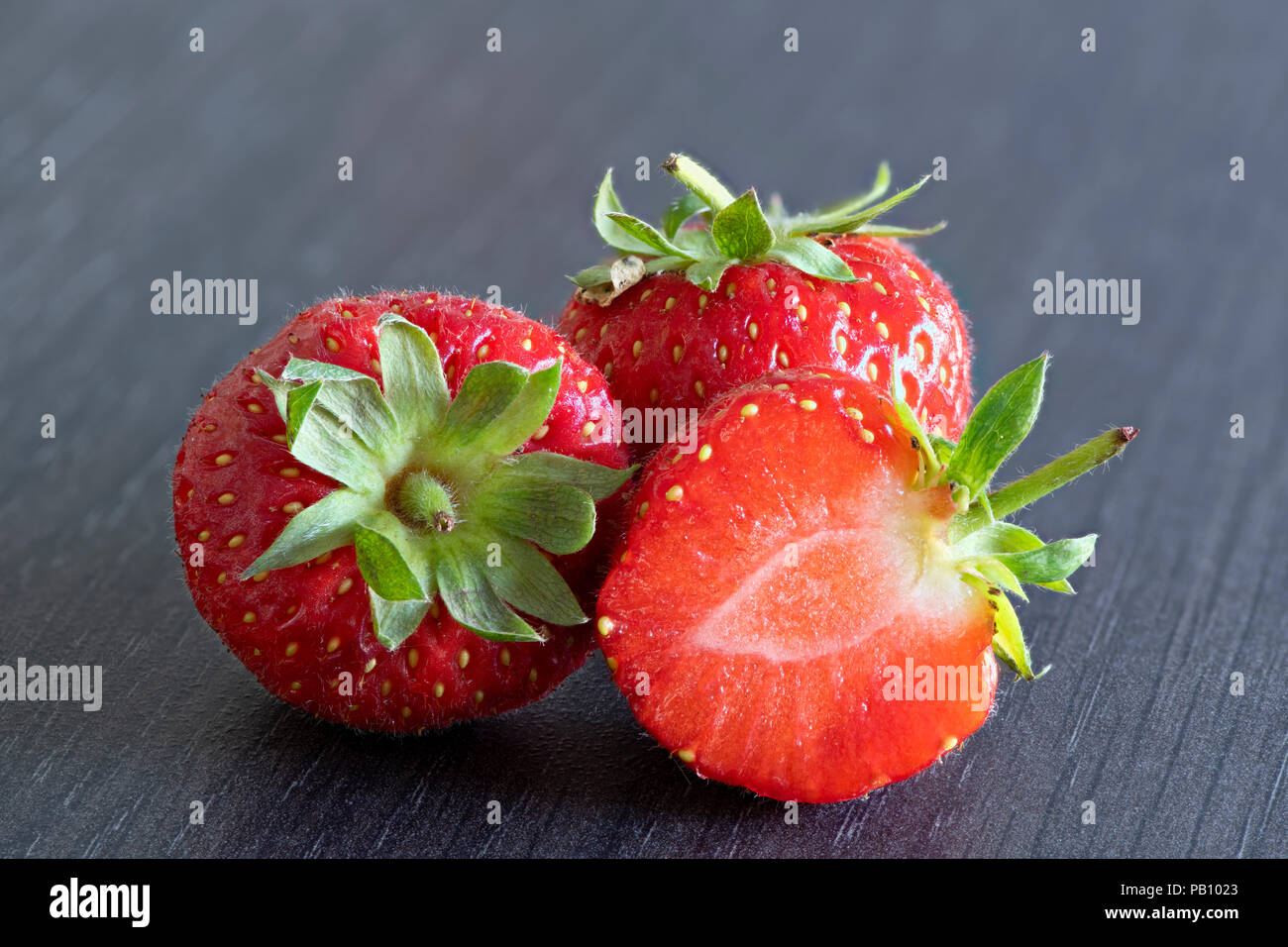 Luscious ripe fresh strawberries on a grey kitchen worktop. One ...