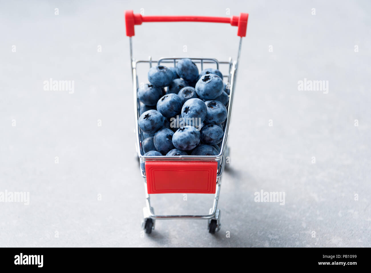Blueberry fruits in mini shopping cart. Selective focus on the ...