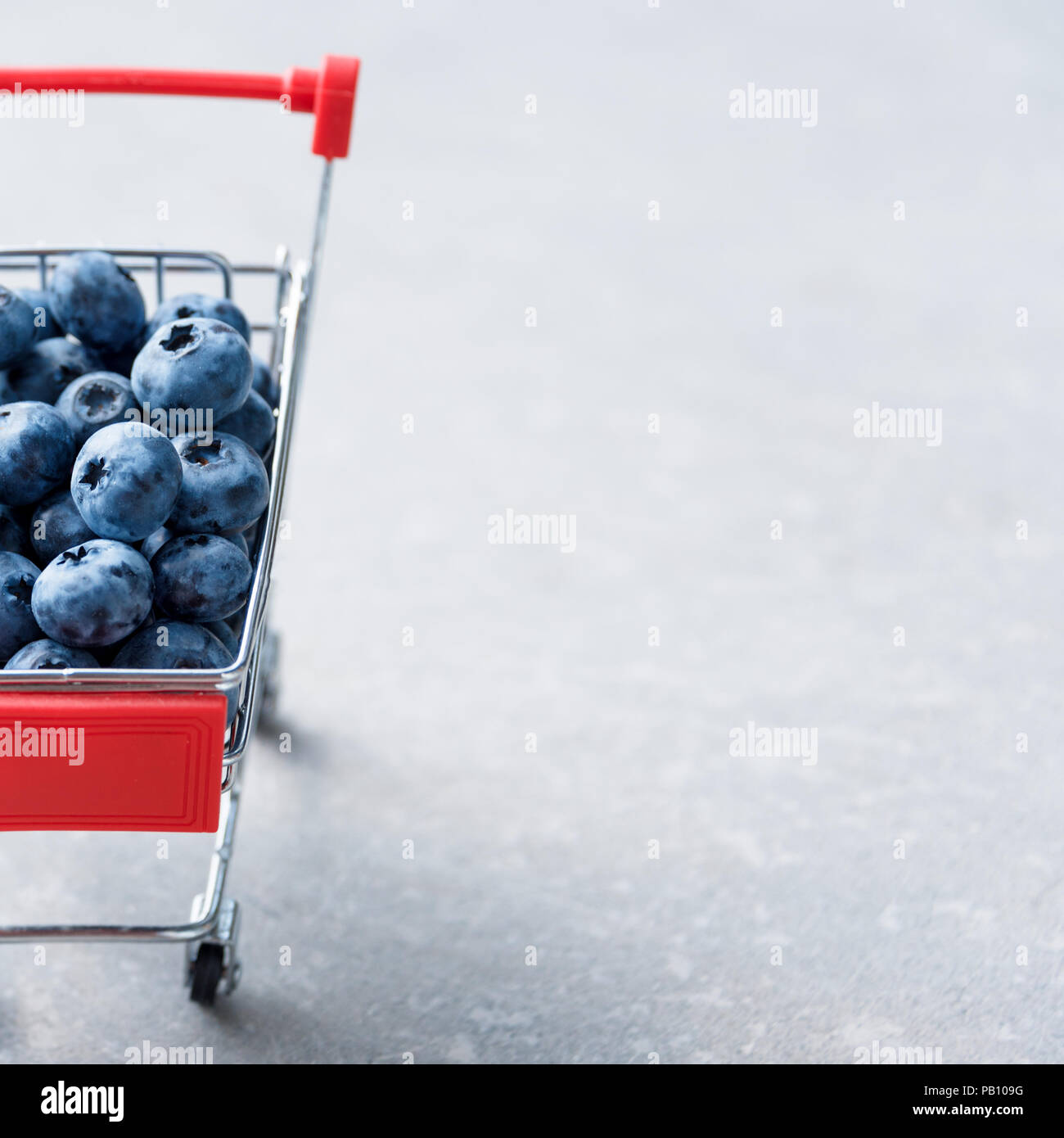 Blueberry fruits in mini shopping cart. Selective focus on the ...