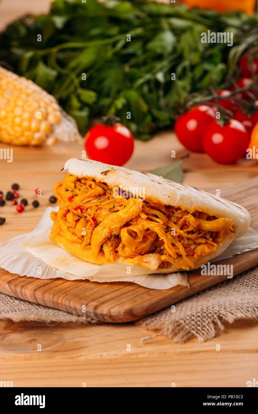 Delicious and provocative arepa with crushed chicken and around it some ...