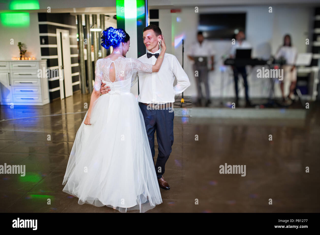 Romantic newly married couple performing their first dance in the ...