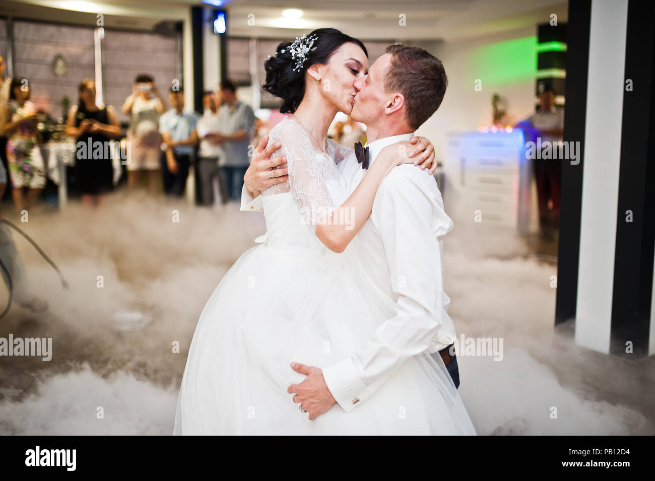 Romantic newly married couple performing their first dance in the ...