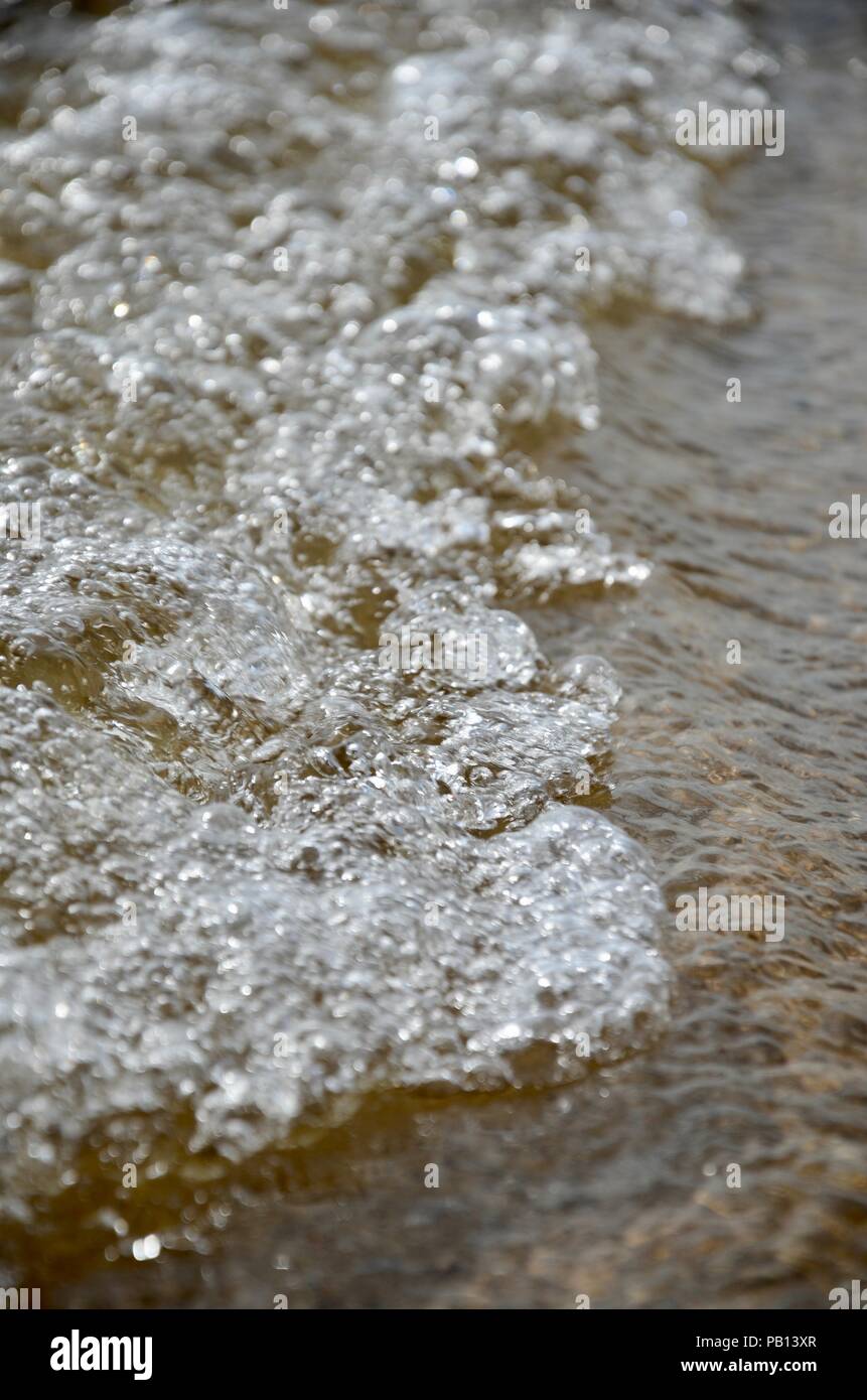 Close up of sea water lapping on to sandy beach, Lincolnshire, England ...