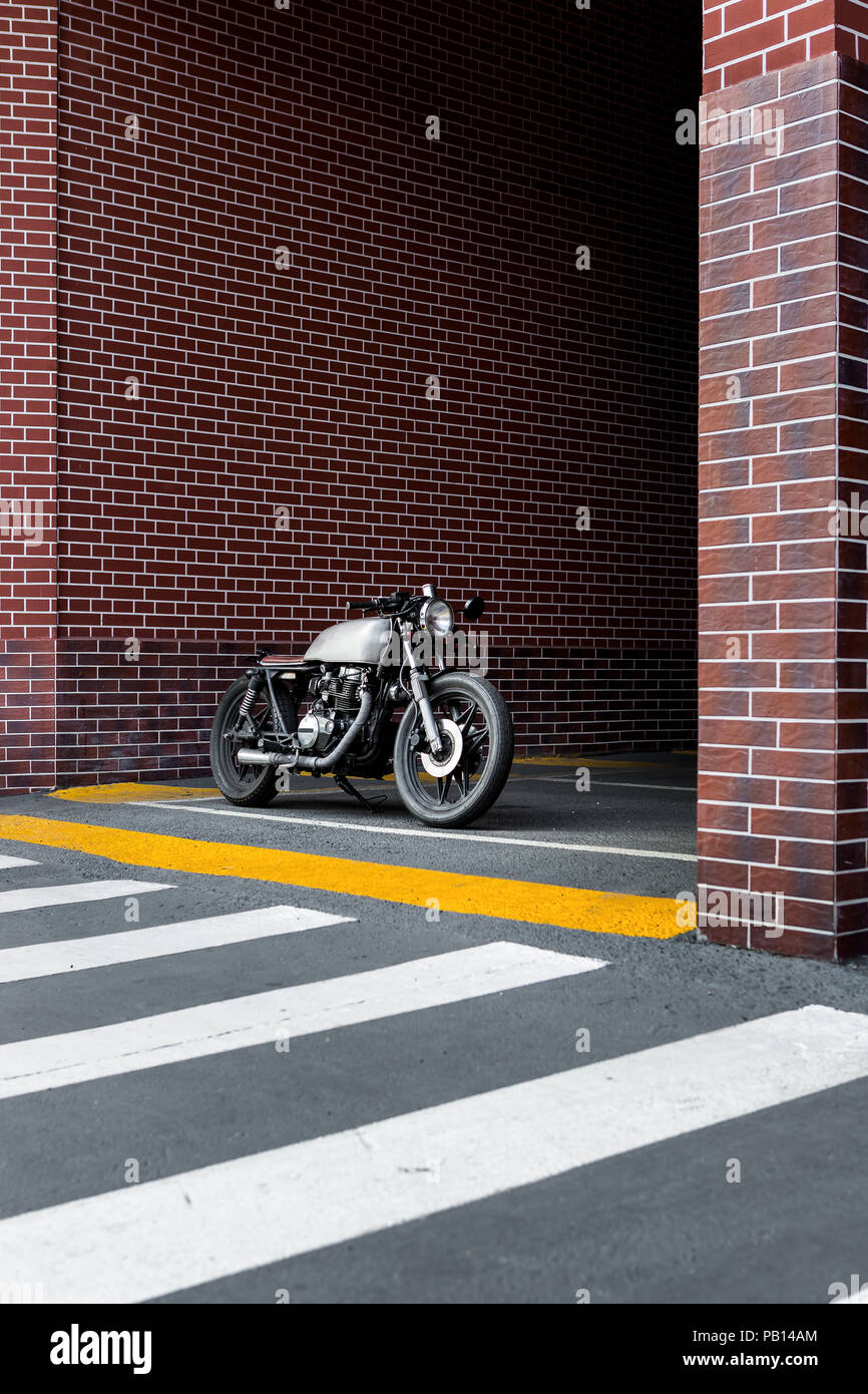 Caferacer motorbike parking near brick wall of finance building ...