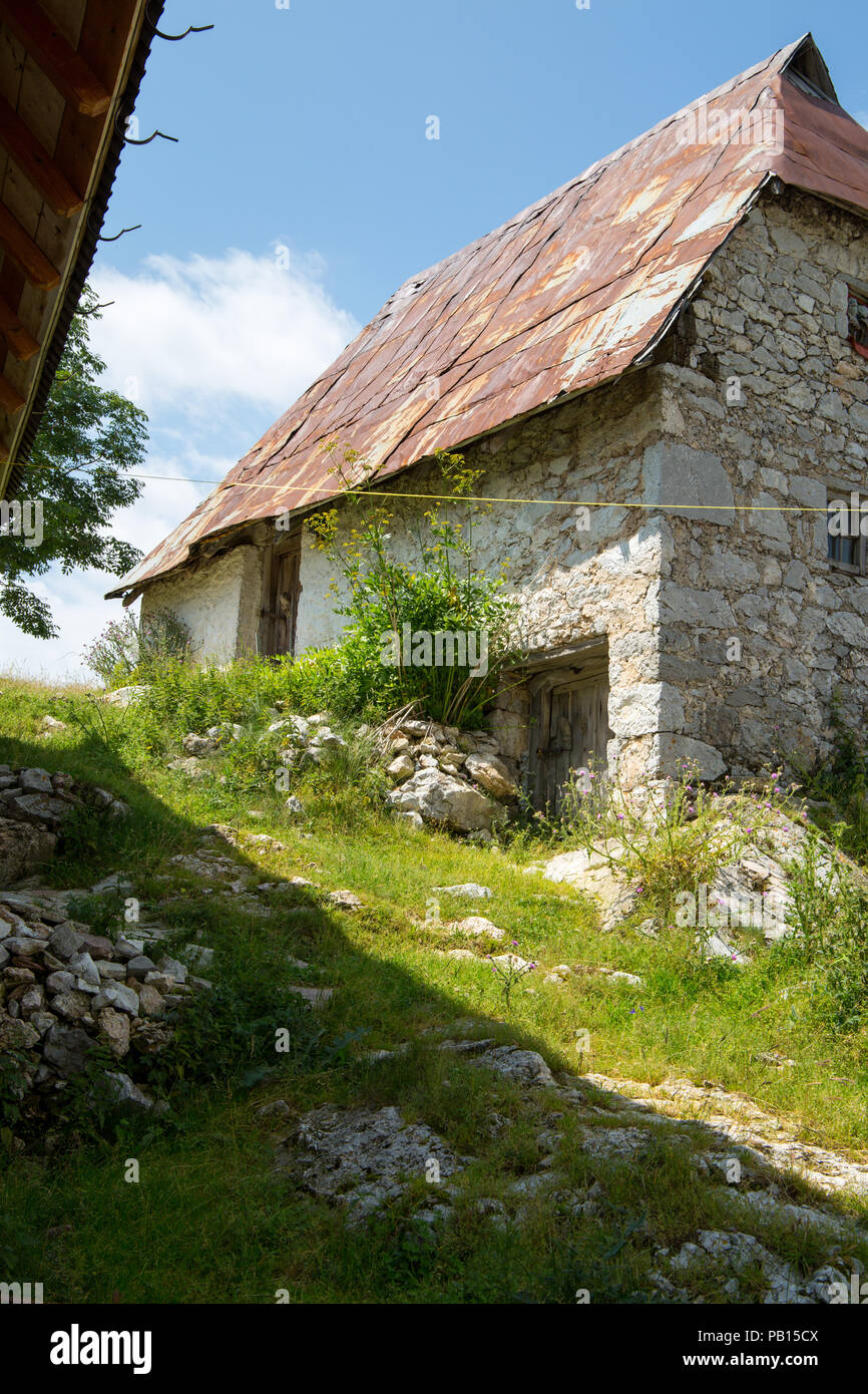 Stone built house surrounded by weeds and grass in highest altitude and ...